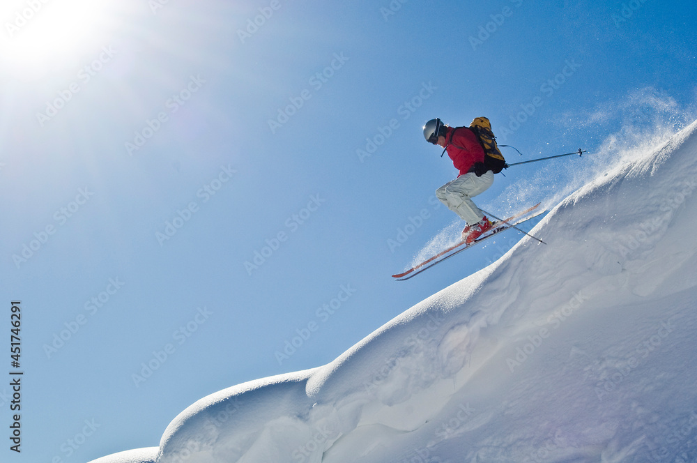 Freeskier springt mutig von einer Wächte in einen steilen Hang Stock ...