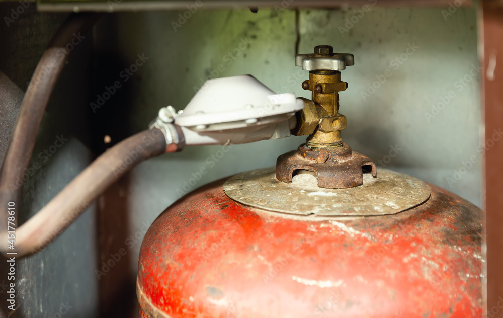 A gas cylinder with a reducer, a hose and a regulator system in the ...