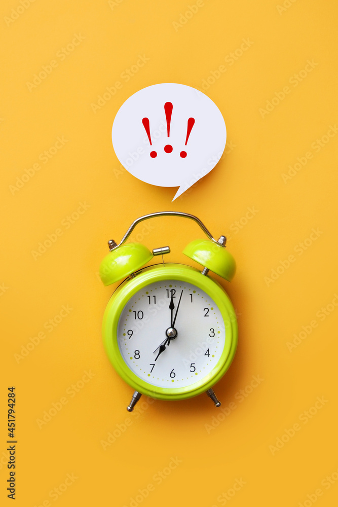 A green alarm clock and exclamation marks above it. A reminder symbol ...