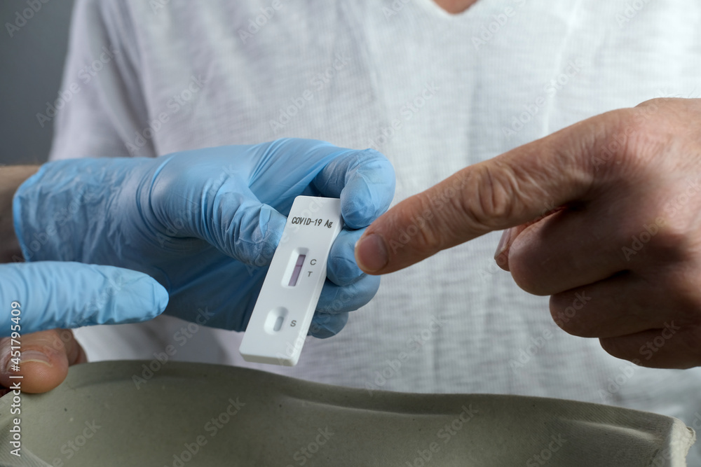 close-up of a male medic's hand holding a test cassette, medical ...