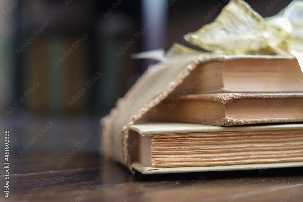 Well read and worn out books wrapped with a hemp and gold ribbon on an ...