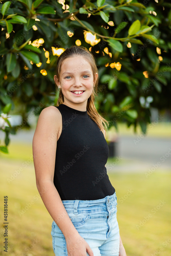 vertical portrait of smiling young tween girl against natural ...