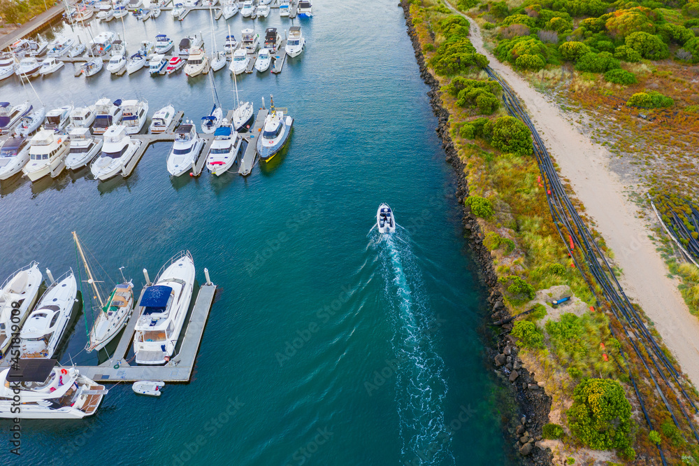 Aerial view of a marina with a small runabout leaving a wake through an ...