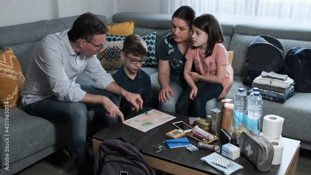 Father explaining to his family the assembly point map while preparing ...