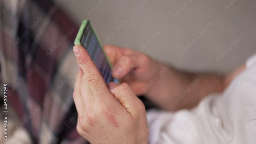 Text a message. Man typing words in messenger, sitting home on sofa in ...