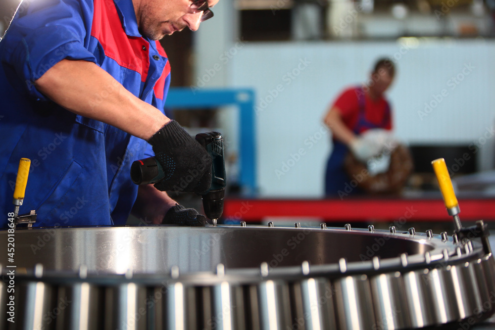 The large diameter bearing is assembled at the factory. The worker ...