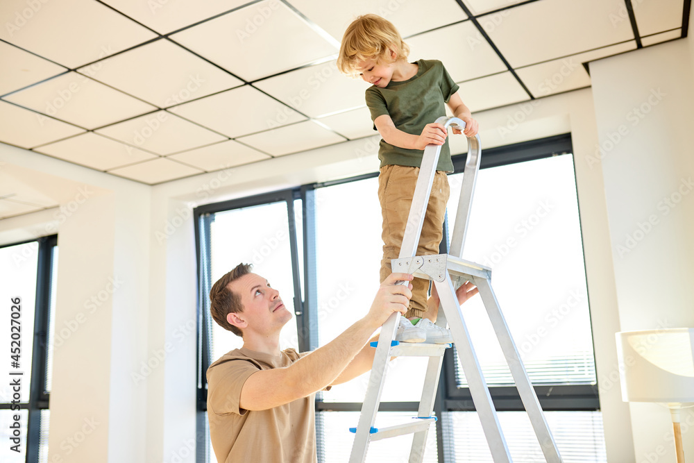 Home makeover, decoration. Little son helping father with building work ...