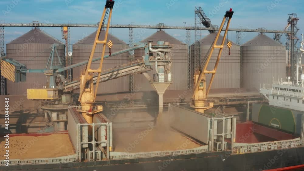 Drone video - loading grain into holds of sea cargo vessel through an ...