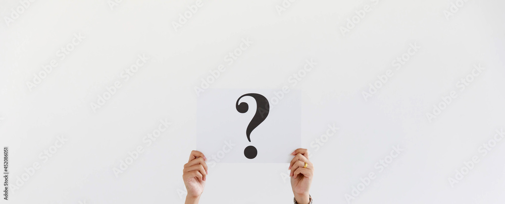 Studio shot of question mark paper cardboard sign holding raise ...