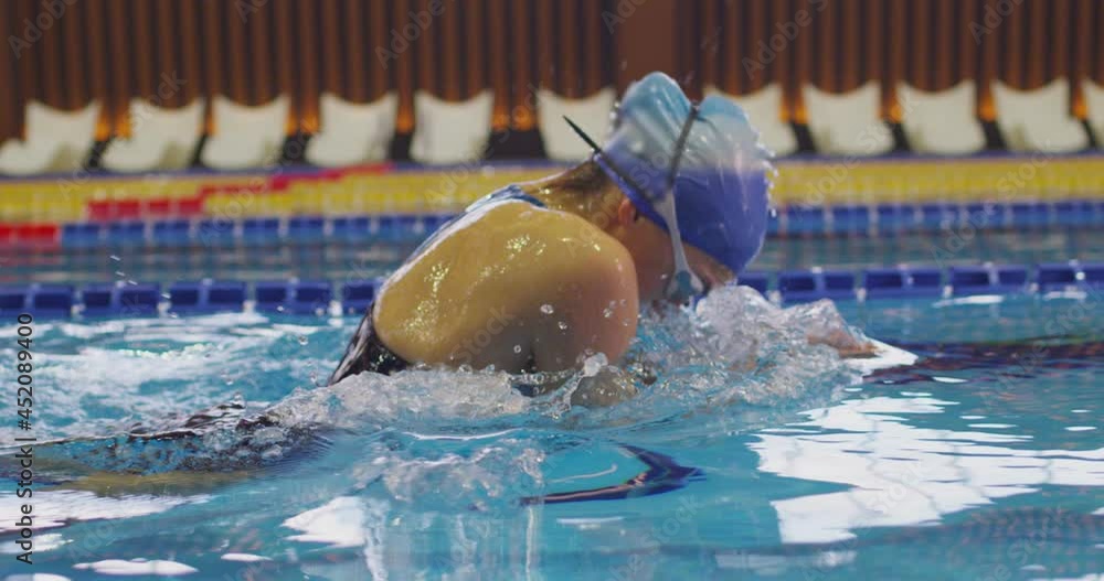 Side view of professional female swimmer in goggles on swimming pool ...