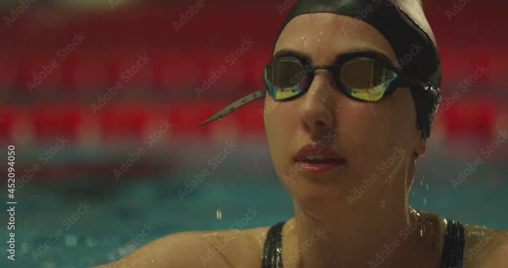 Portrait of professional female swimmer in goggles on swimming pool ...