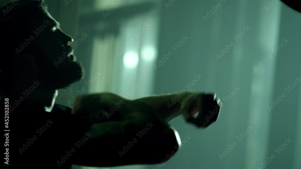 Young professional boxer boxing speed punching bag . Side view of young ...