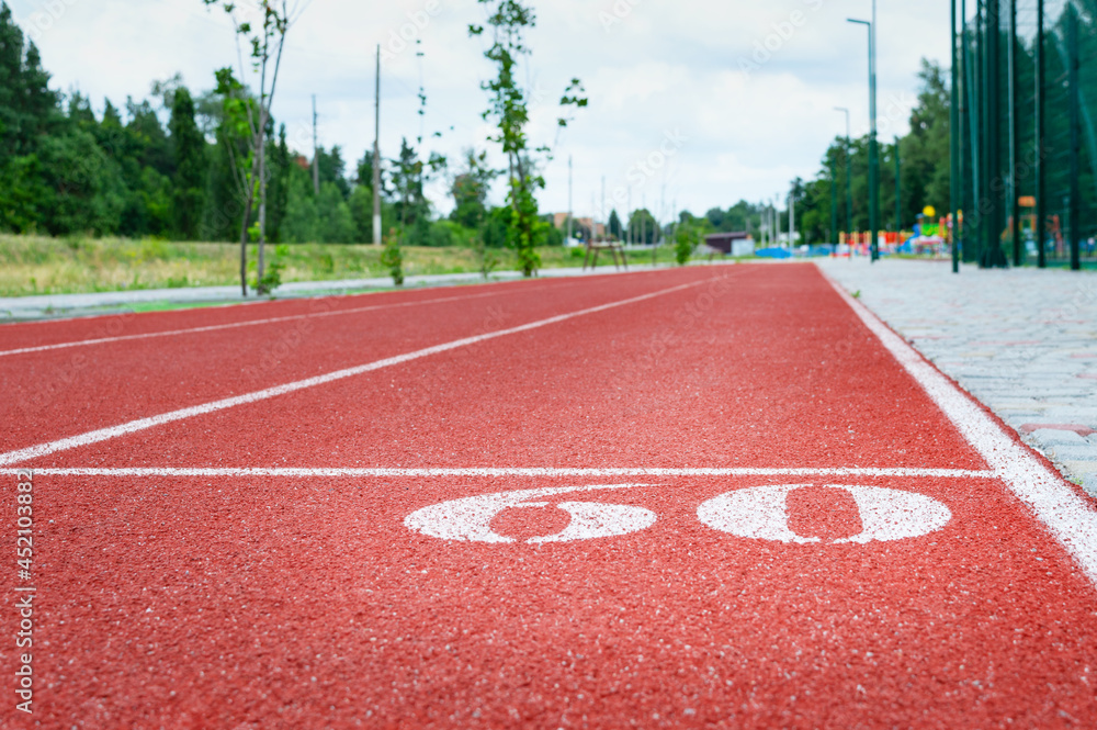 "60" mark on running track in the sport stadium. Sign in white numbers ...