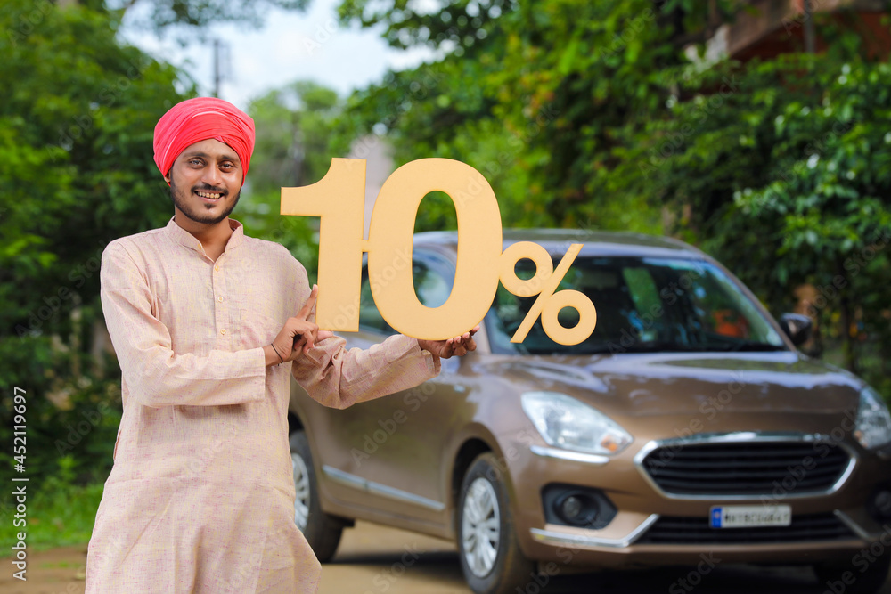 Indian farmer holding ten percent sign board and standing with new car ...