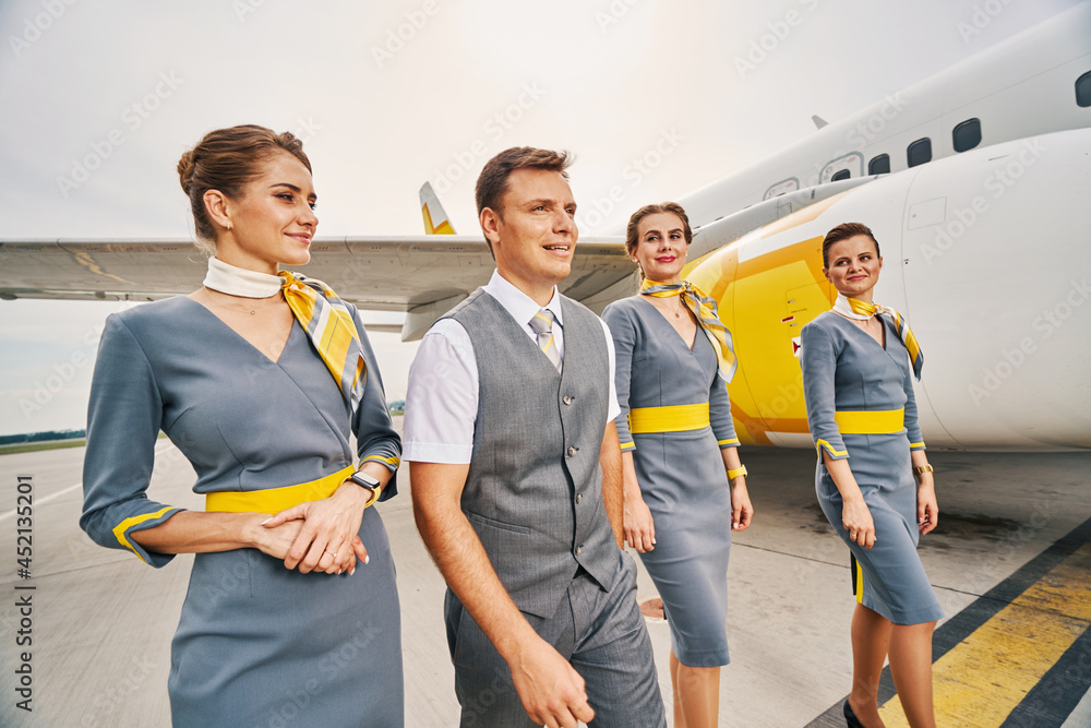 Four attractive aircrew members standing by a landed aircraft ภาพถ่าย ...