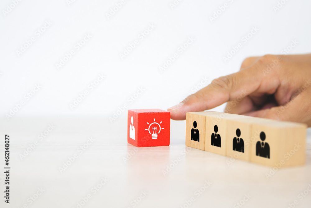 Hand choose human with light bulb icon on cube wooden block stack ...