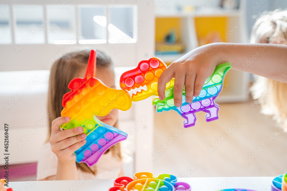 Little girls,kids,sisters play with colorful pop it children room ...