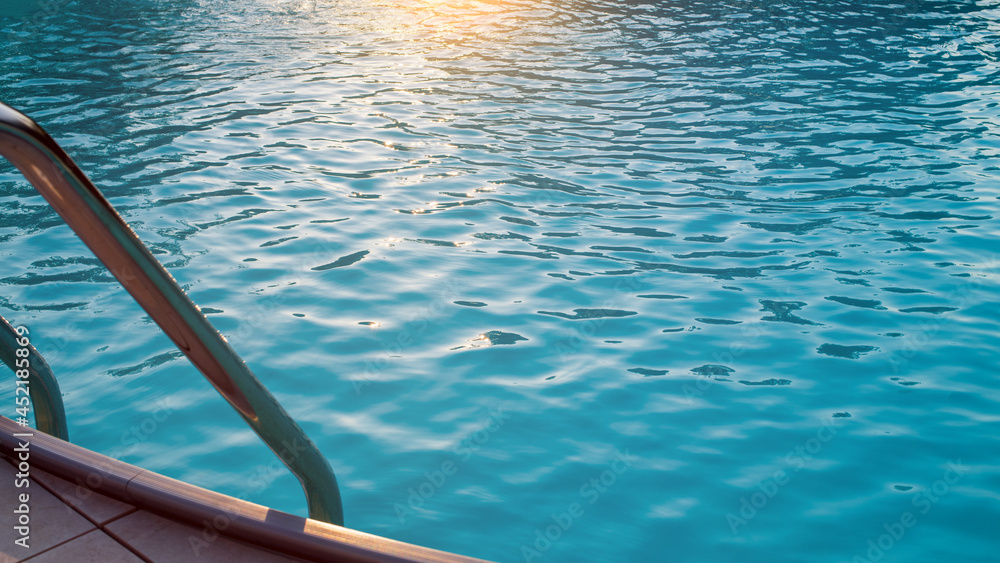Hintergrund Poolwasser im Sonnenuntergang mit Einstiegsleiter und Fliesen Stock Photo | Adobe Stock