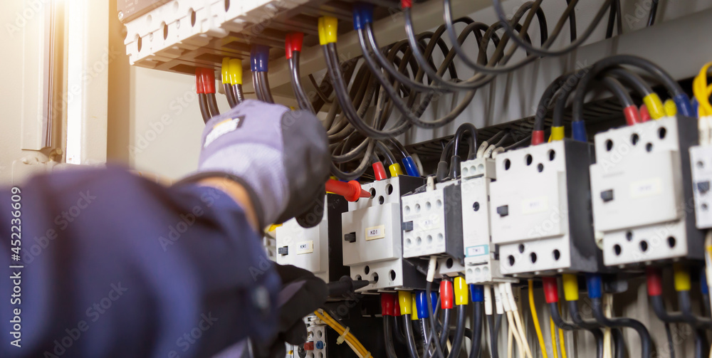 Electrician engineer tests electrical installations and wires on relay ...