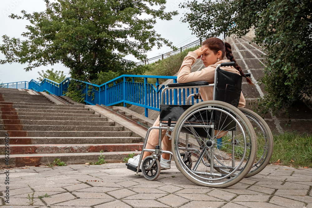 The girl is sitting in a wheelchair facing difficulties alone ...