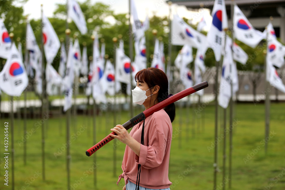Korean woman practicing kendo in a hi-dong kendo pose with a sword. 스톡 ...