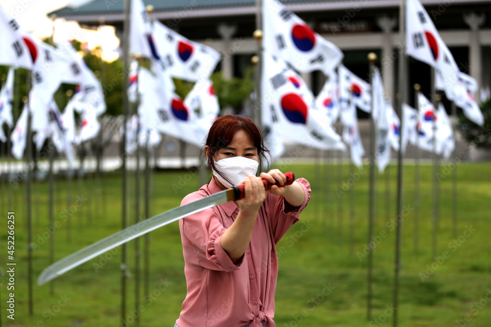 Korean woman practicing kendo in a hi-dong kendo pose with a sword ...