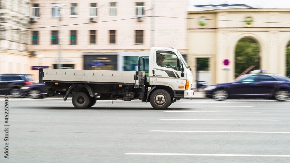 Hyundai hd35l light flatbed truck on the street in motion. Side view of ...