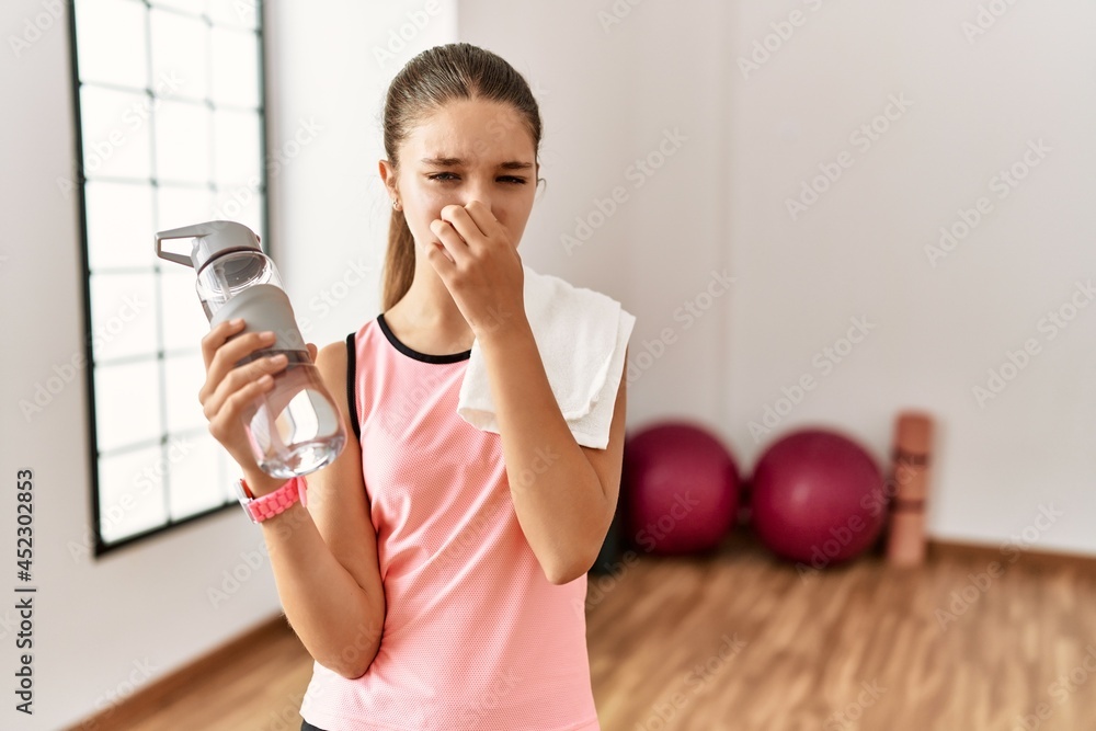 Young brunette teenager wearing sportswear holding water bottle ...