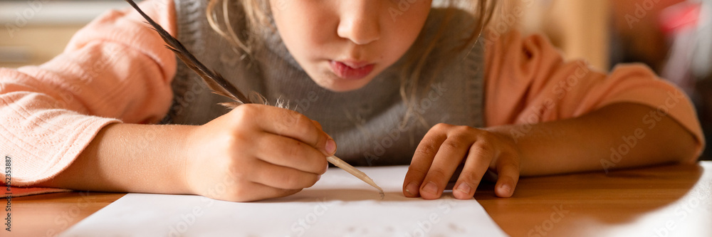 little seven year old kid girl draws a disappearing drawing on a paper ...