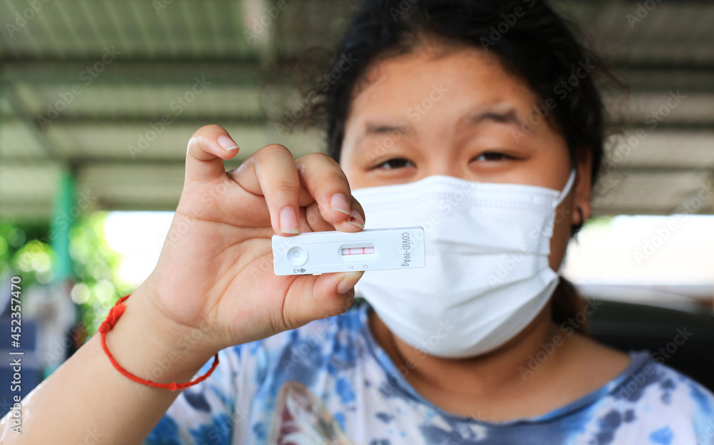 Young girl show Covid-19 antigen rapid test with positive result . Swap ...