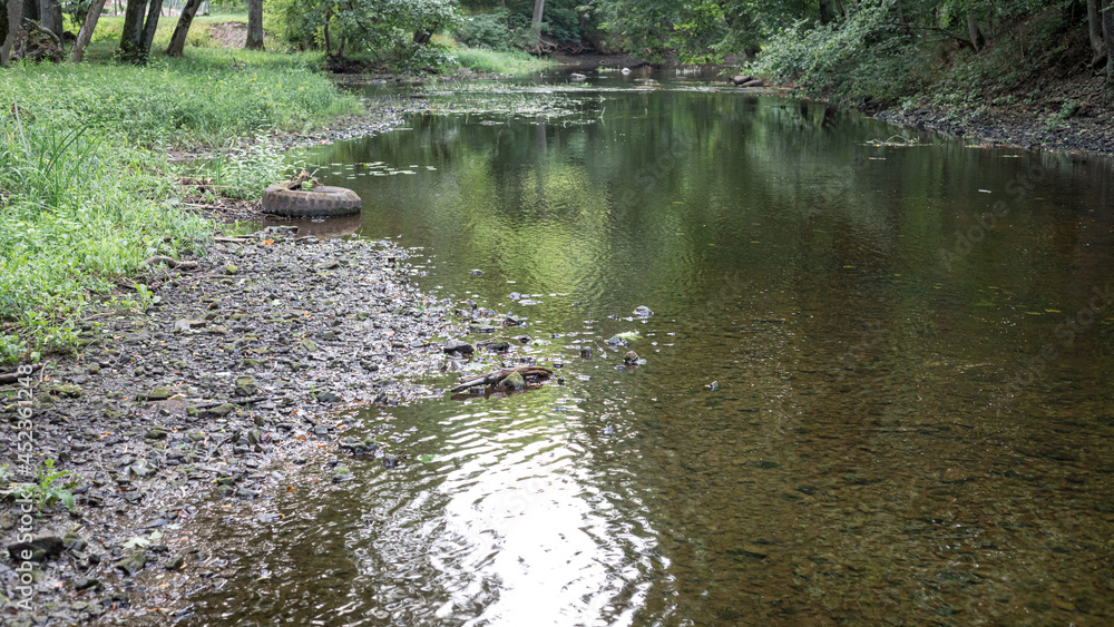 Foto Stock a tire from a car in the river pollutes the environment ...