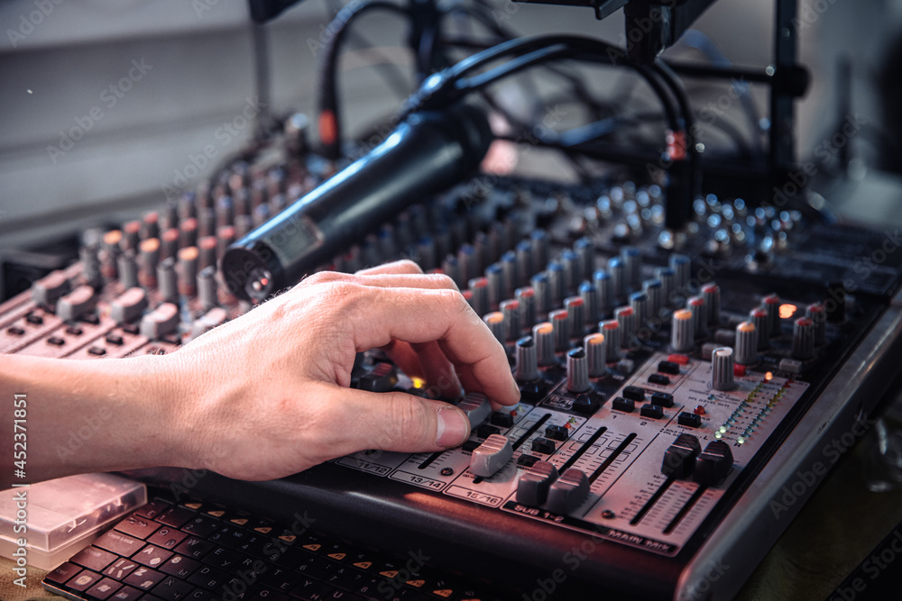 DJ's hand touching the audio control panel Stock Photo | Adobe Stock