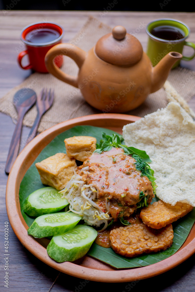 Nasi Pecel and two cups of tea as background. Nasi Pecel is Indonesian ...