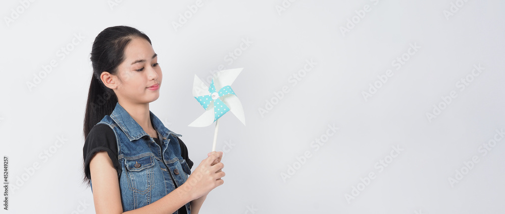 Teenage woman and paper windmill toys. Portrait teen with blue color ...