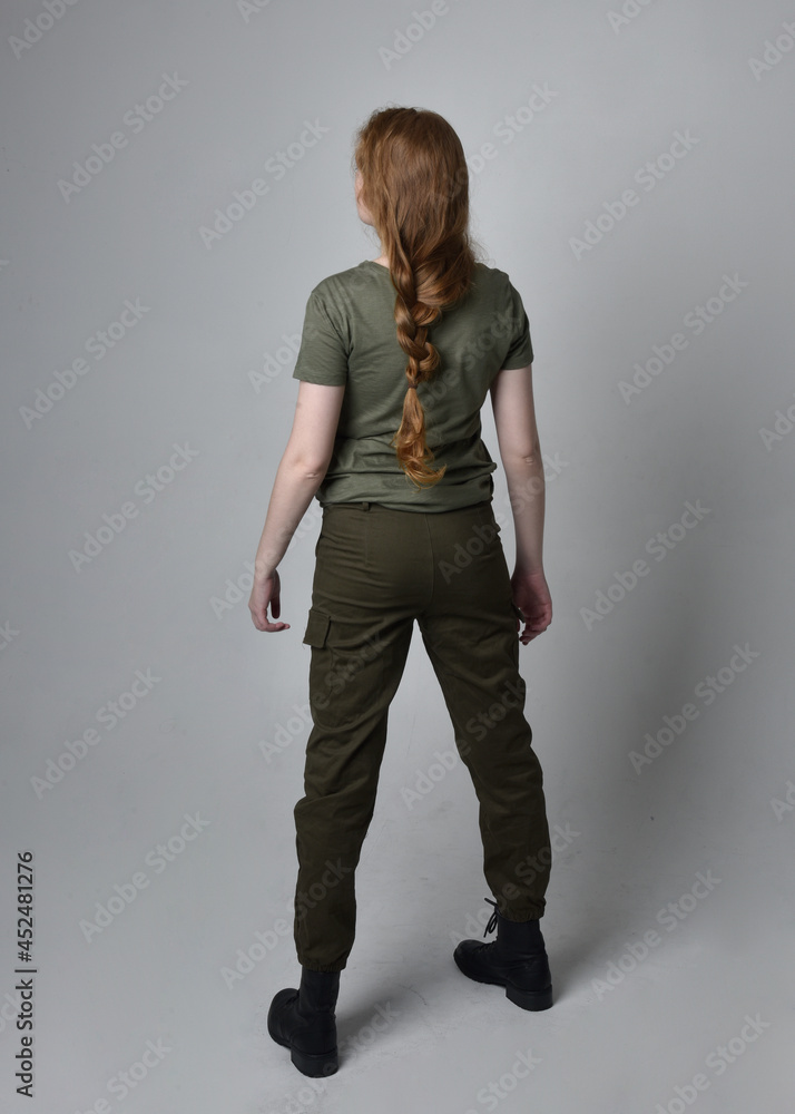 Full length portrait of pretty red haired woman wearing army green ...