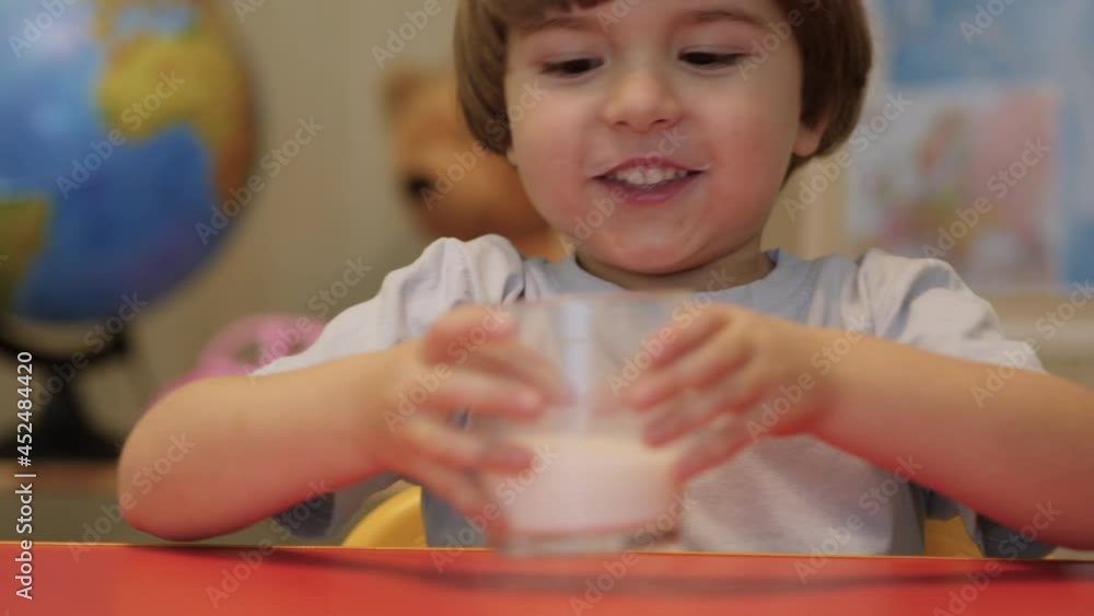 Mother Pouring out a Glass of Milk for Her Son. Slow motion. Closeup ...