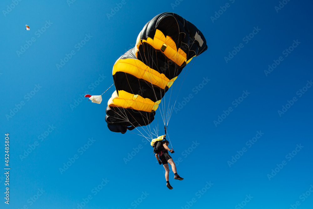 Parachute in the sky. Skydiver is flying a parachute in the blue sky ...