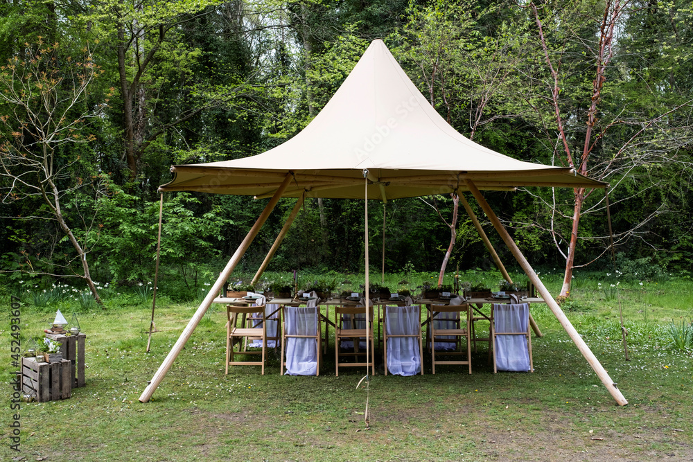 Dining table and chairs under a canopy for a woodland naming ceremony ...