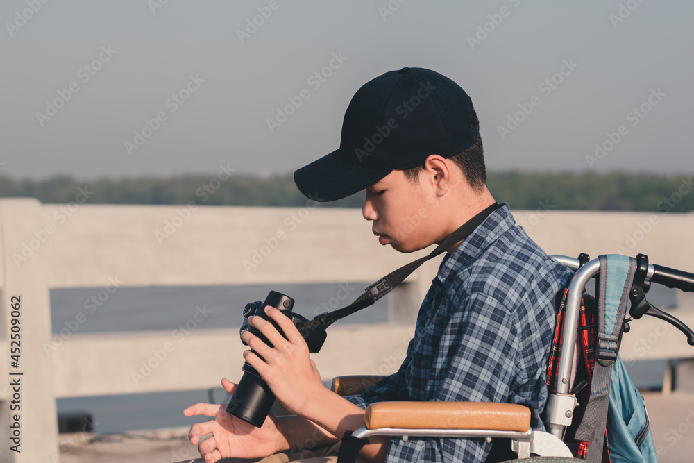 Disabled teenage boy son wheelchair holding a camera to take photo by ...