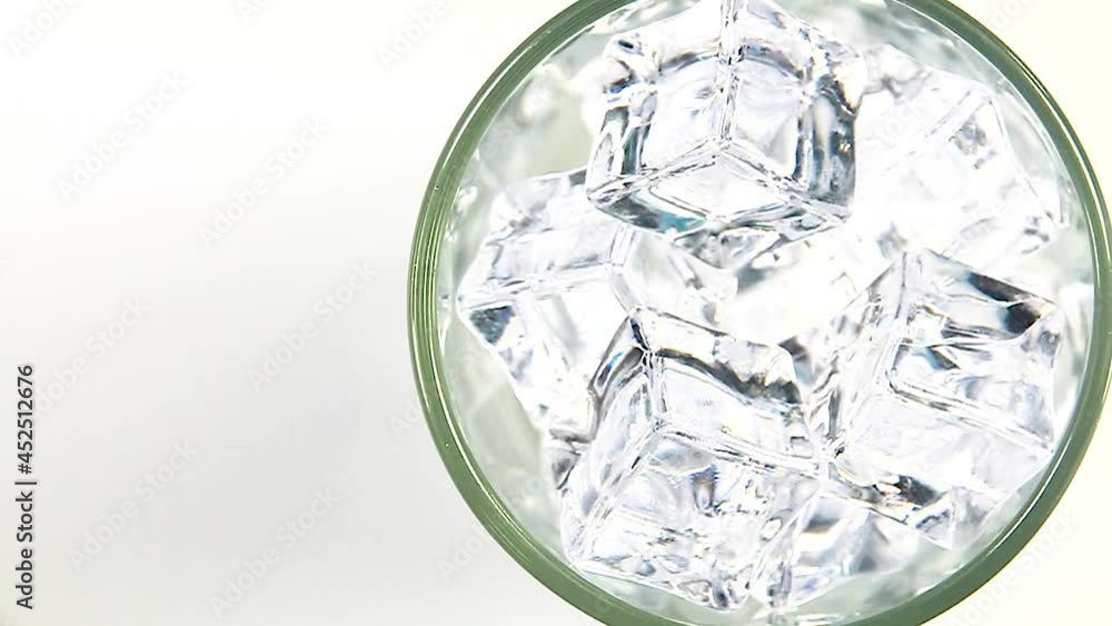 Cola water poured into a glass from above filled with ice cubes,bubble ...