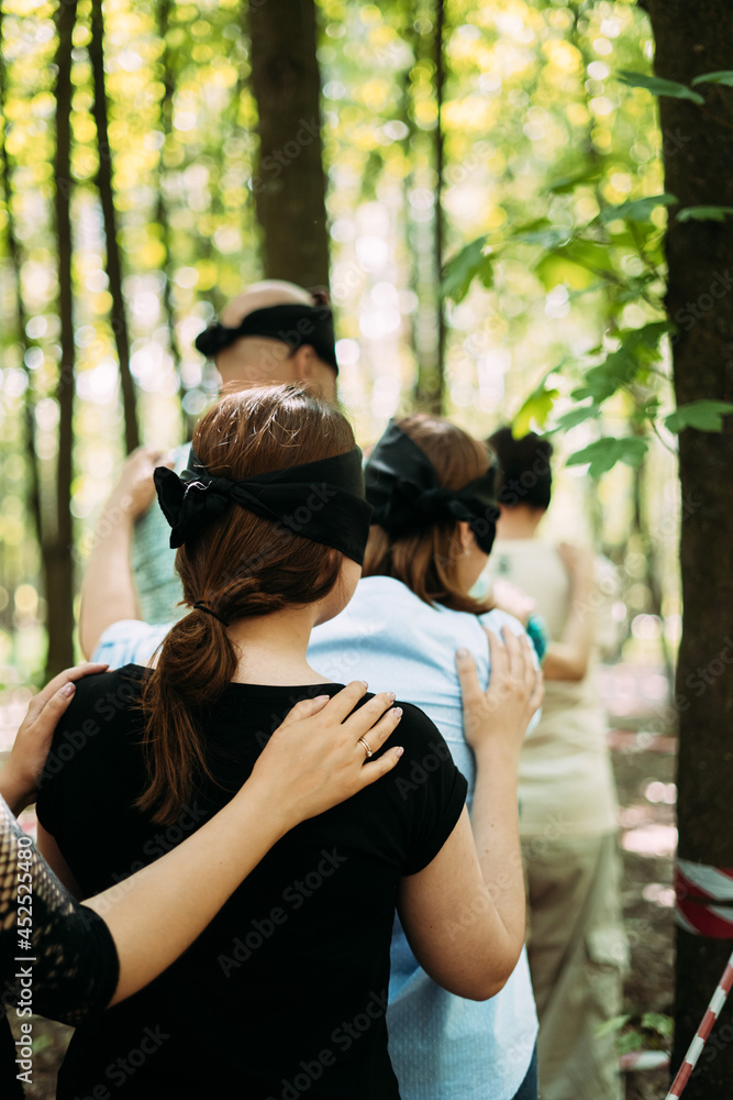 Team building exercise. People stand behind each other and hold their ...
