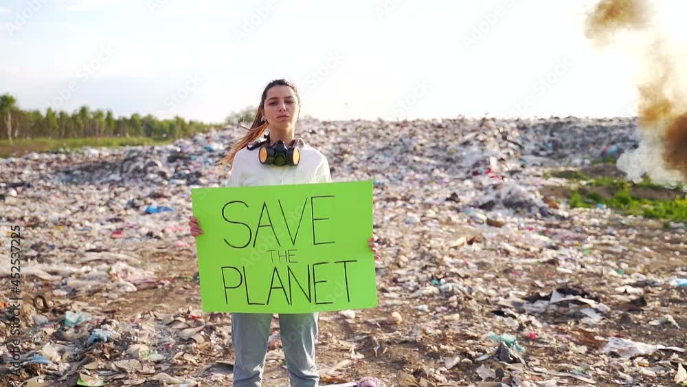 young woman activist with a poster in hands save the planet stands ...
