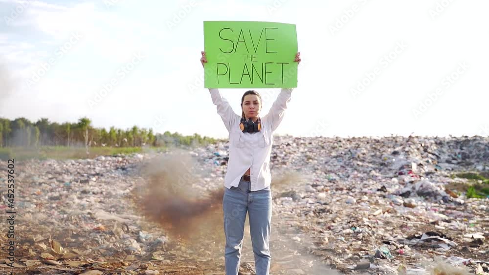 young woman activist with a poster in hands save the planet stands ...