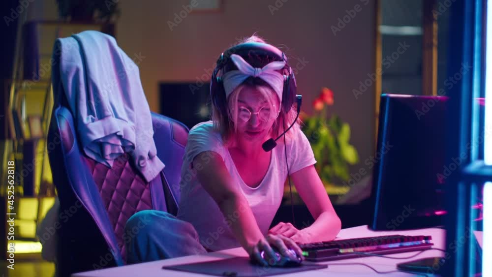 Asleep woman gamer waking up and continuing to play computer video game ...