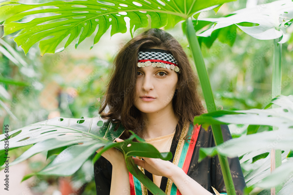 The girl from Jordan on the background of plants and palm leaves ...