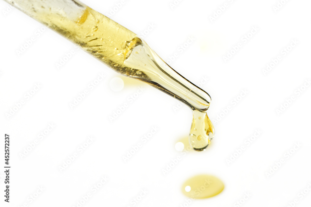 Liquid oil serum drop in pipette isolated on white background. Retinol ...