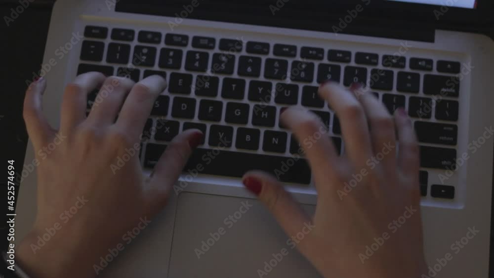 An HD top view footage of female fingers with painted nails typing in a ...