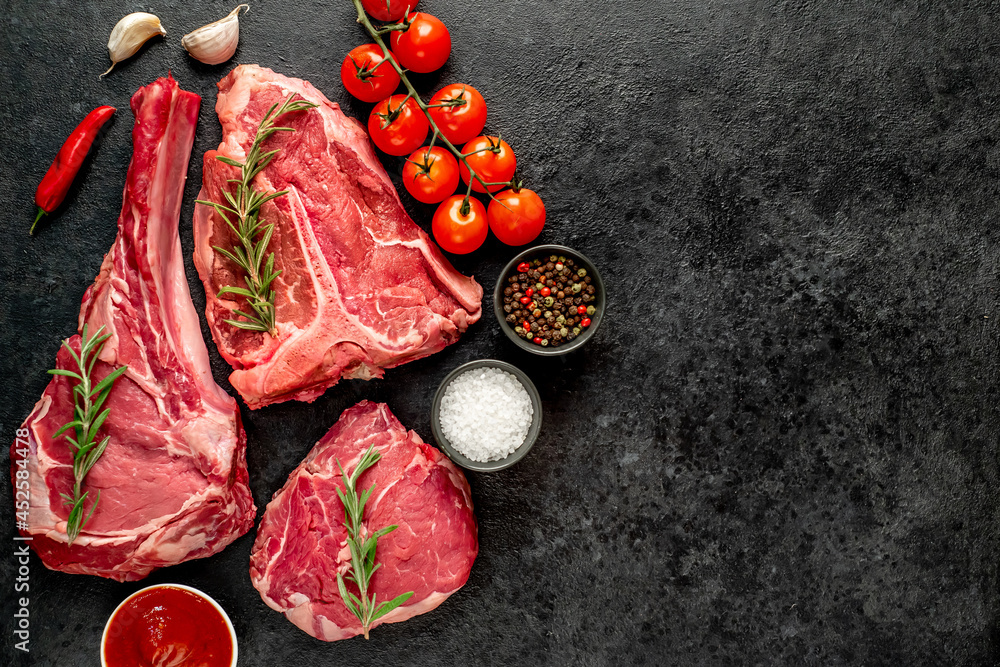 A variety of raw steaks. Ribeye steak, tomahawk, T-bone, on a stone ...