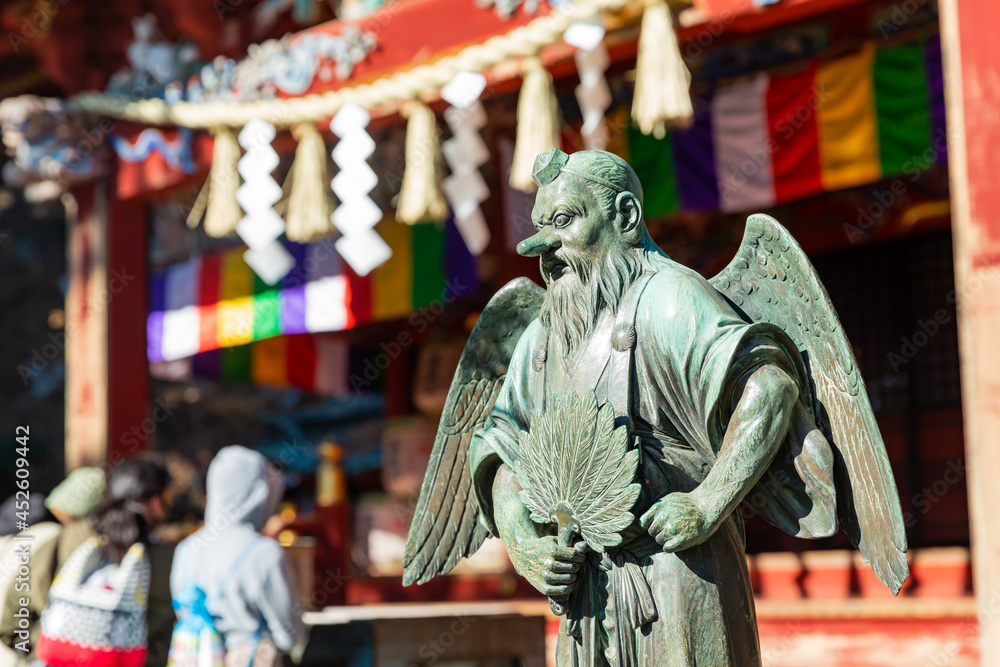 statue of long-nosed goblin "tengu" and japanese prayers in front of ...