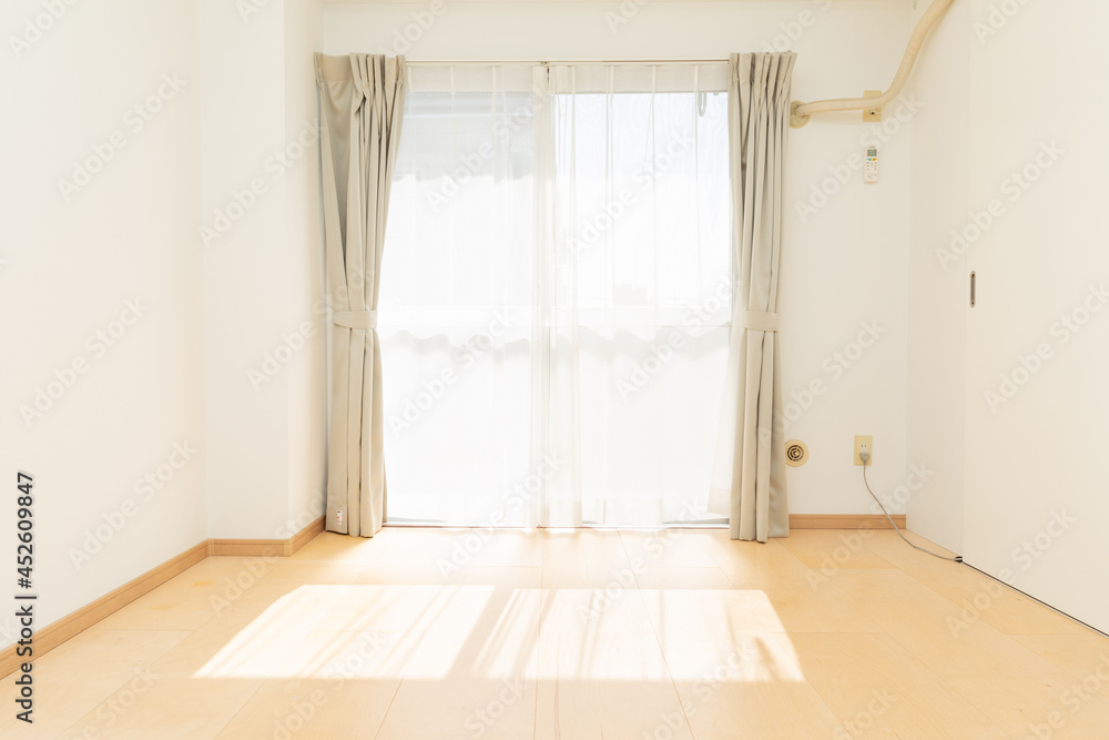 sunlight coming inside empty room with white wall and wooden bwon floor ...